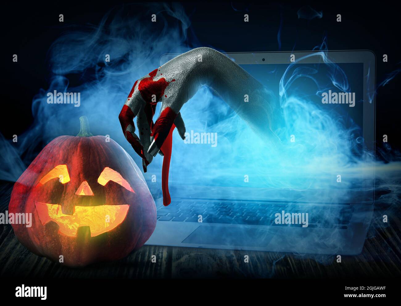 Halloween Pumpkin And Witch Sticking Hand Out Of Laptop Screen On Dark halloween-pumpkin-and-witch-sticking-hand-out-of-laptop-screen-on-dark