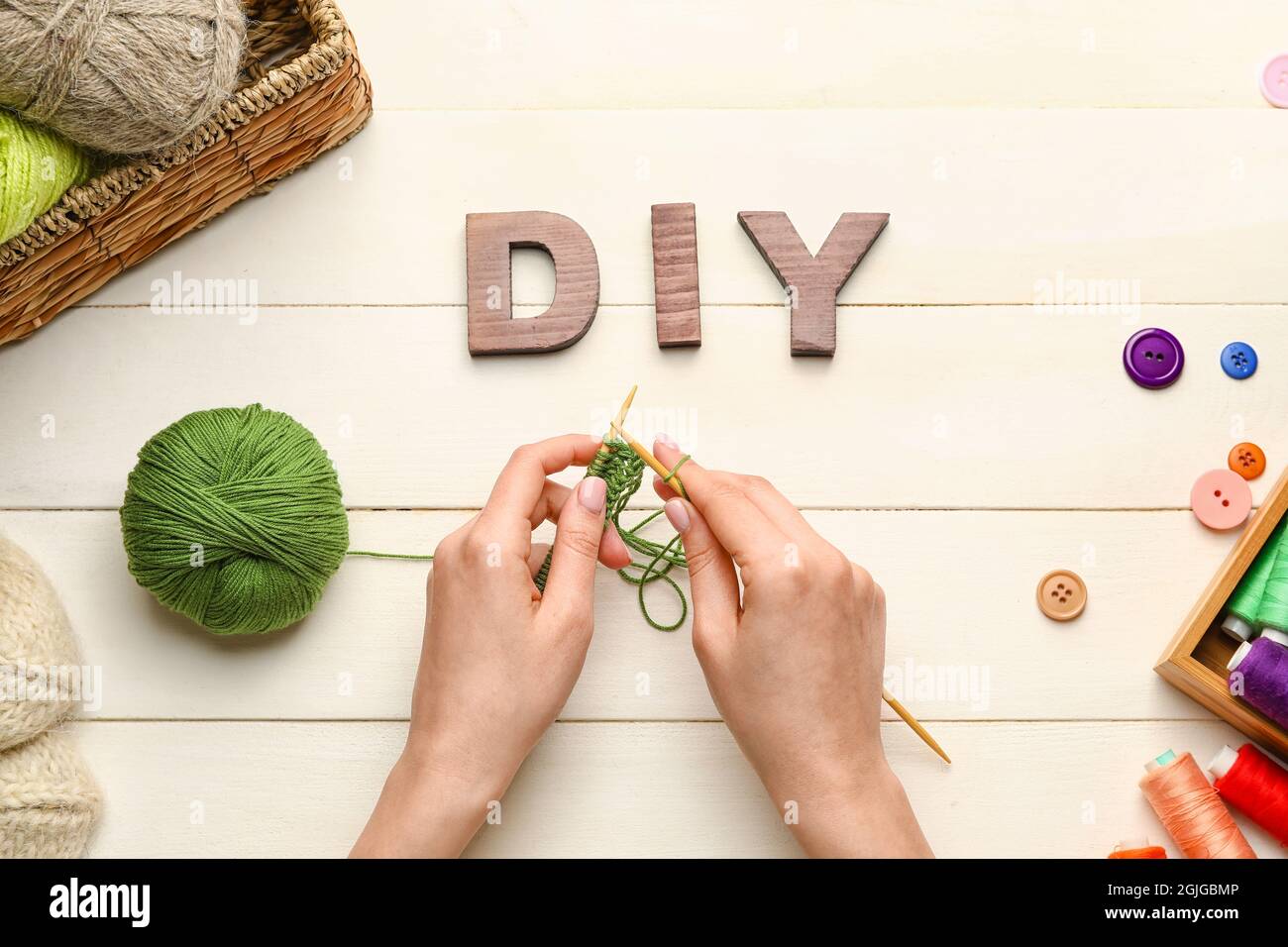 Word DIY and woman knitting on white wooden background Stock Photo - Alamy
