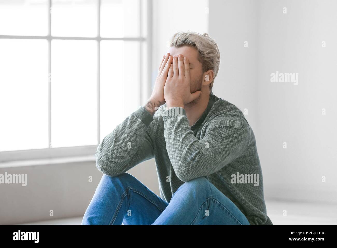 Depressed young man in empty room Stock Photo - Alamy