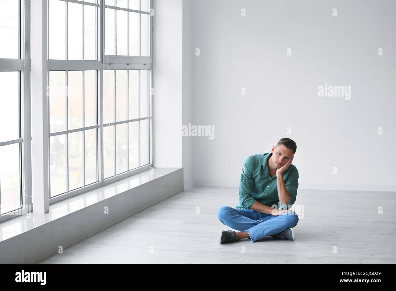 Depressed young man in empty room Stock Photo - Alamy