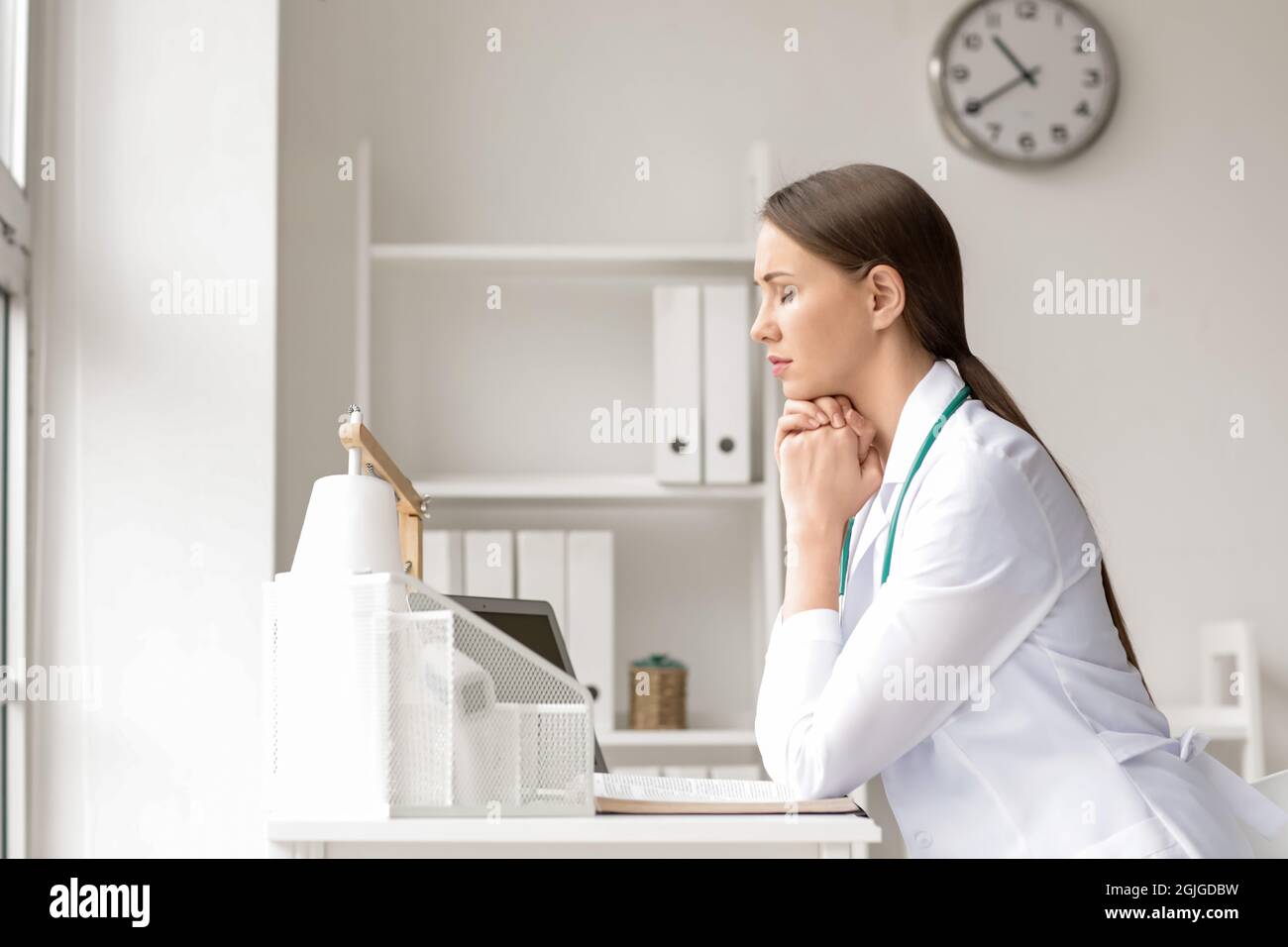 Praying female doctor in clinic Stock Photo - Alamy