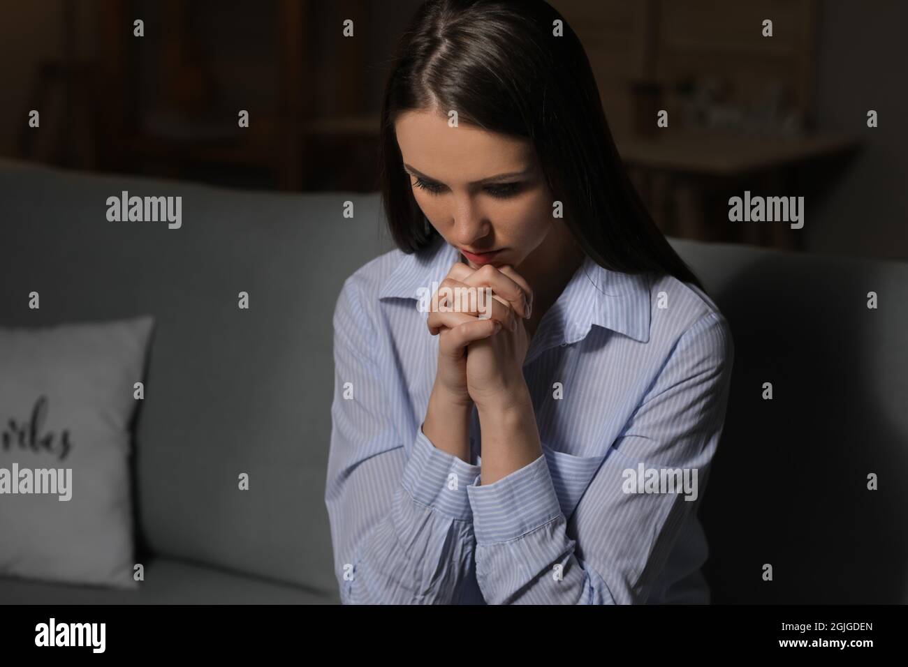 Praying young woman at home in evening Stock Photo - Alamy