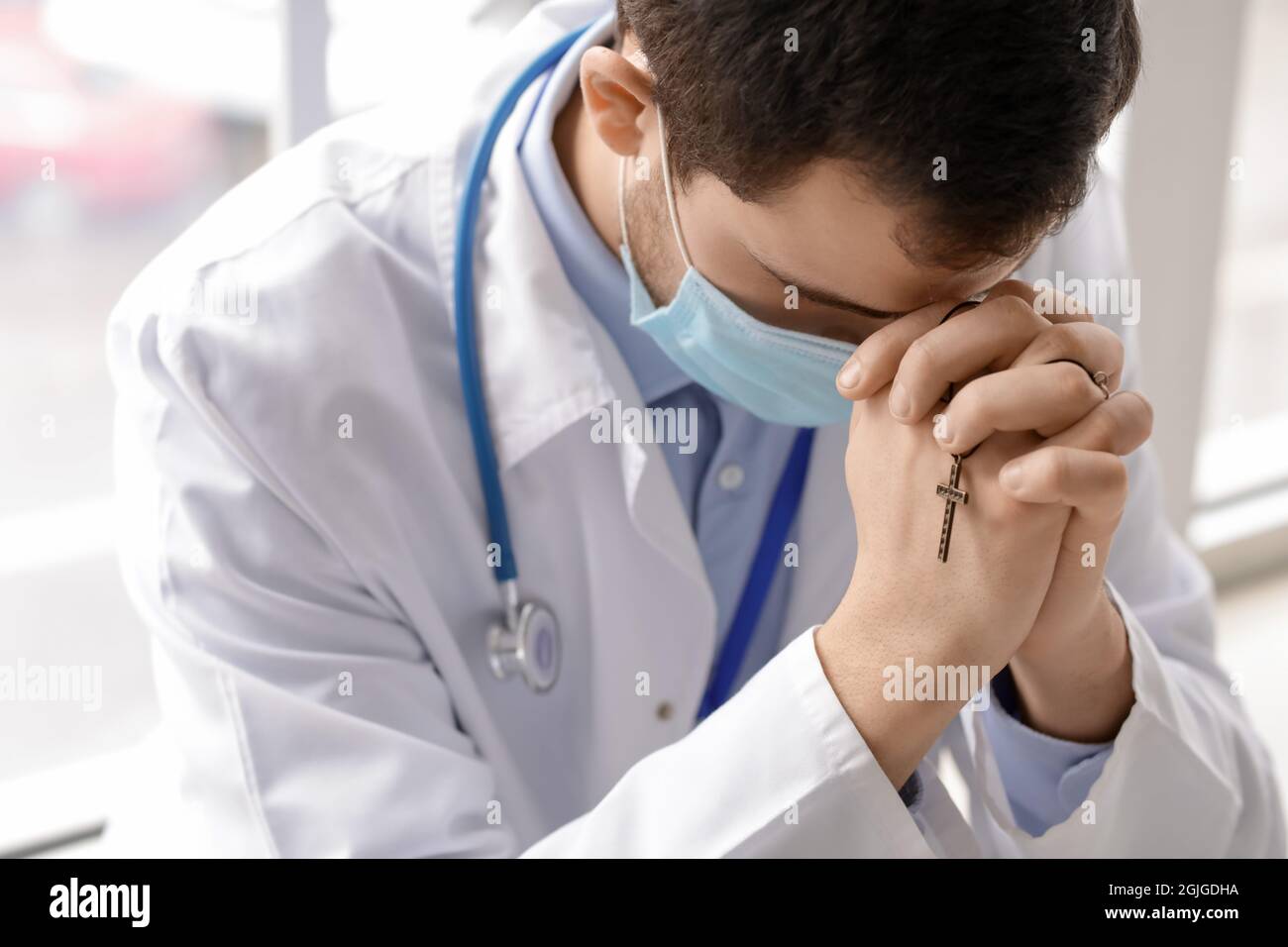 Religious doctor praying in clinic Stock Photo - Alamy
