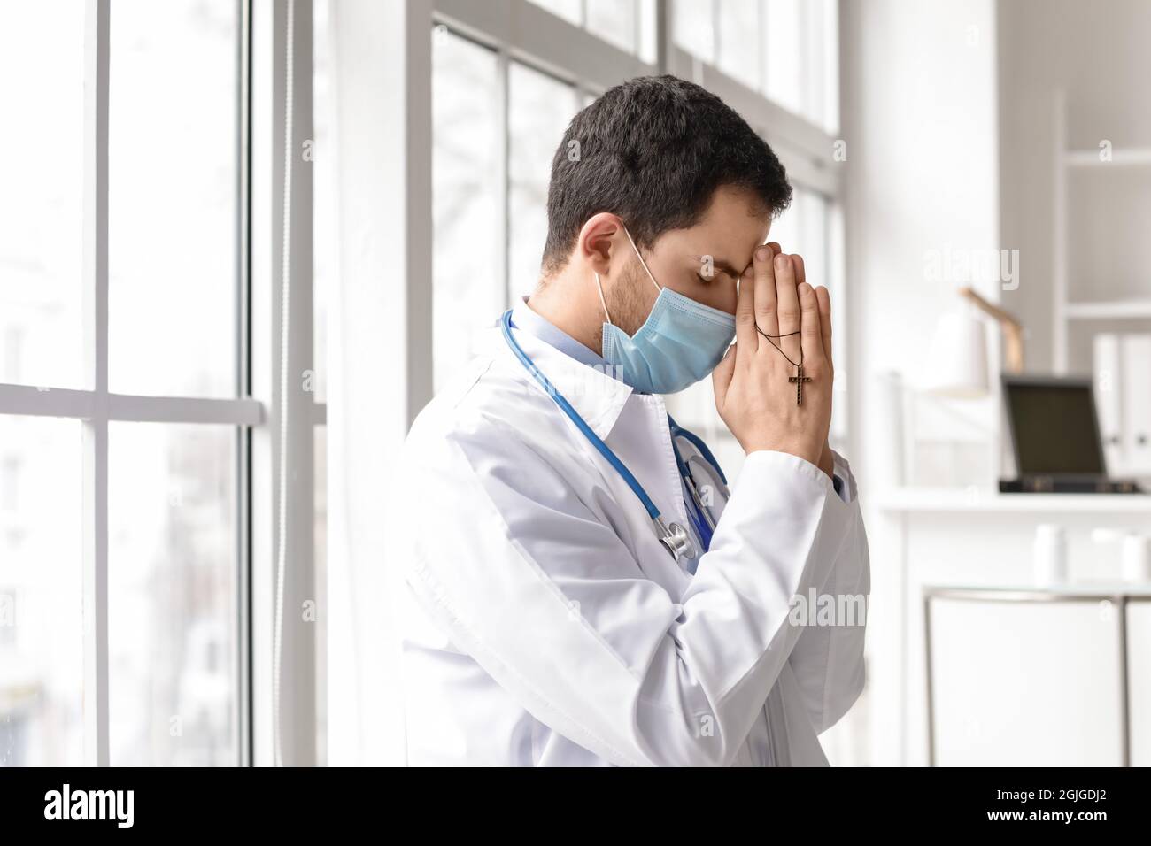 Religious doctor praying in clinic Stock Photo - Alamy