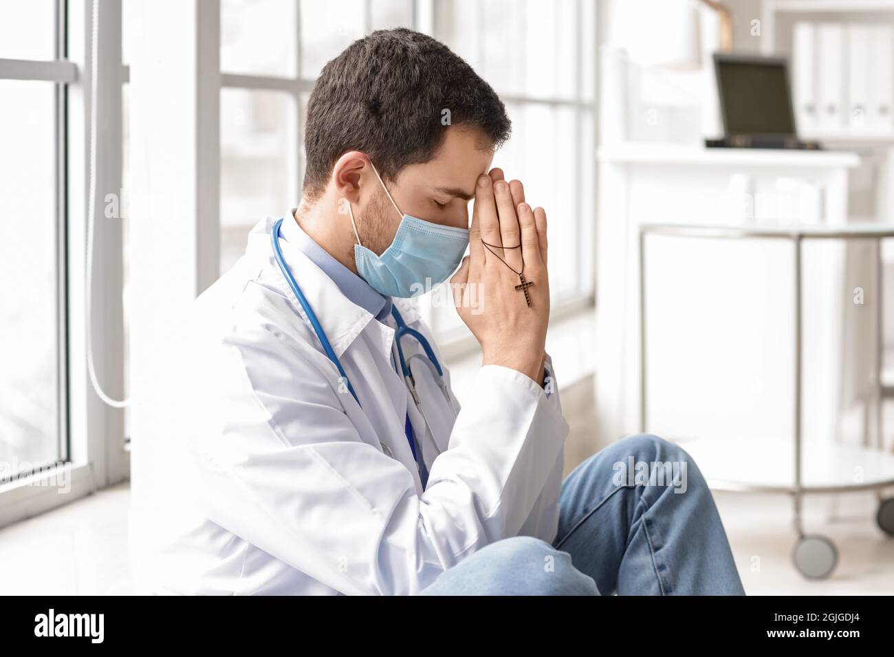 Religious doctor praying in clinic Stock Photo - Alamy