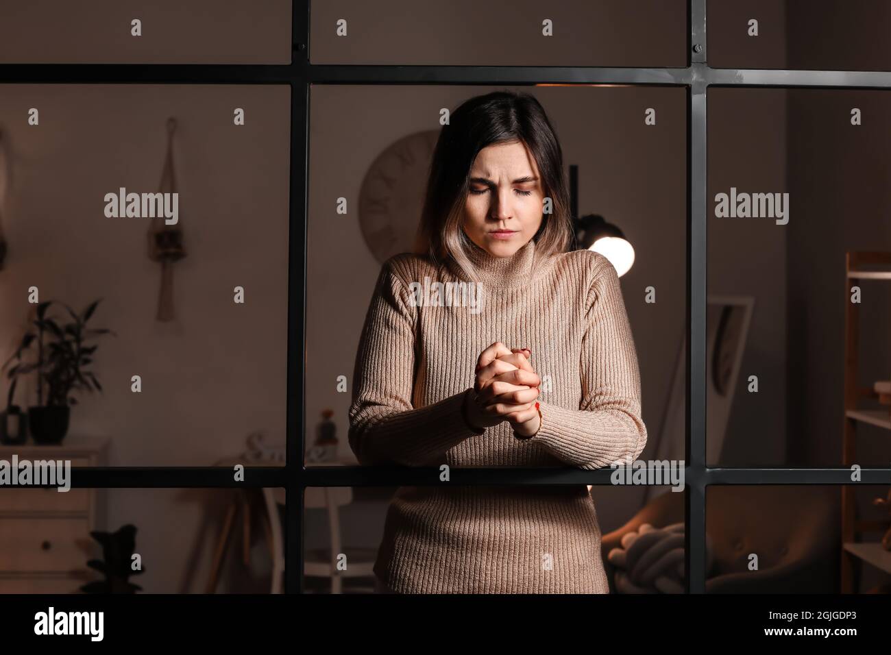 Religious young woman praying to God at home in evening Stock Photo - Alamy