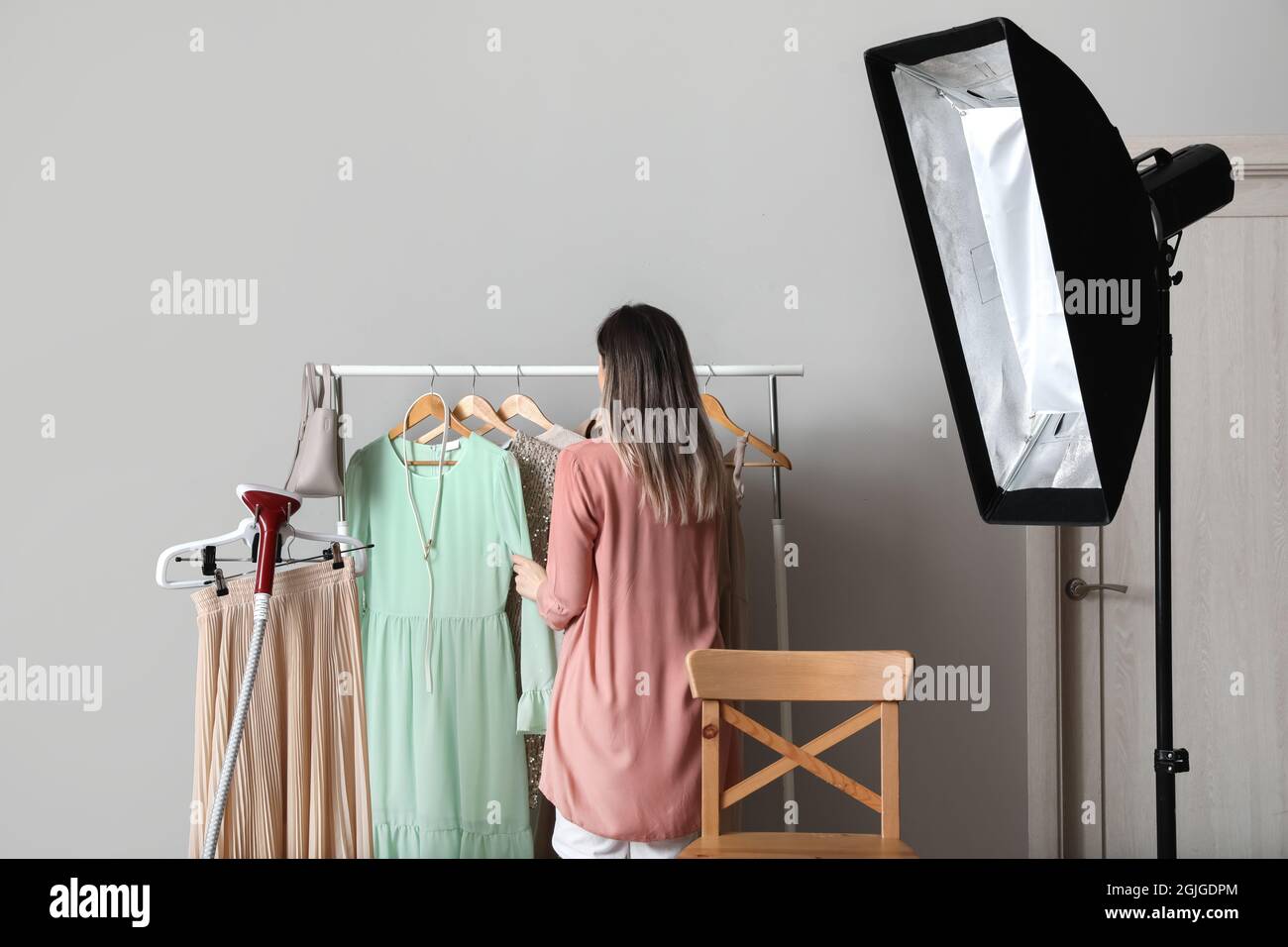 Female stylist choosing clothes for shooting in photo studio Stock ...