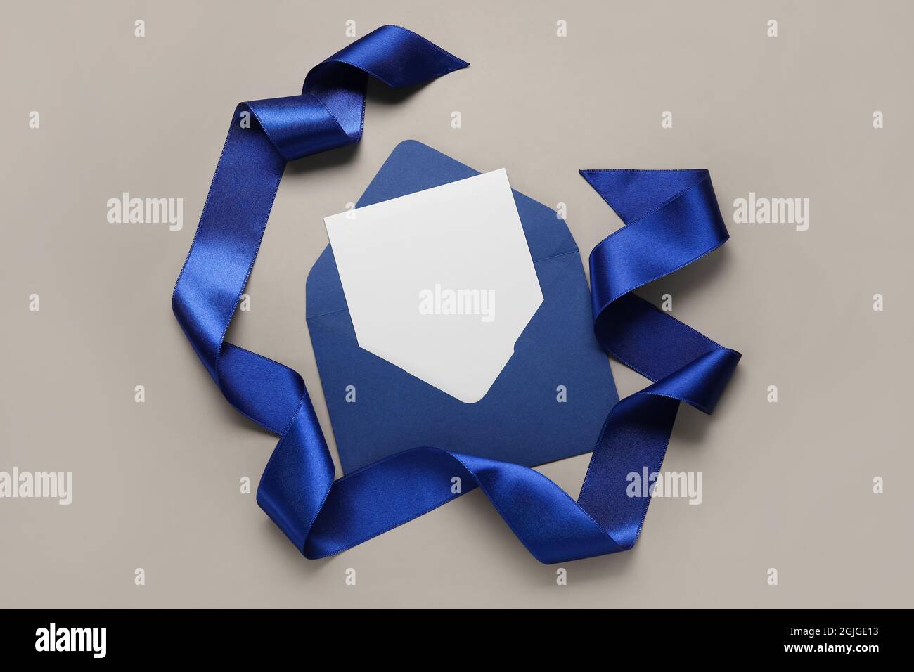 Envelope with blank card and ribbon on grey background Stock Photo - Alamy