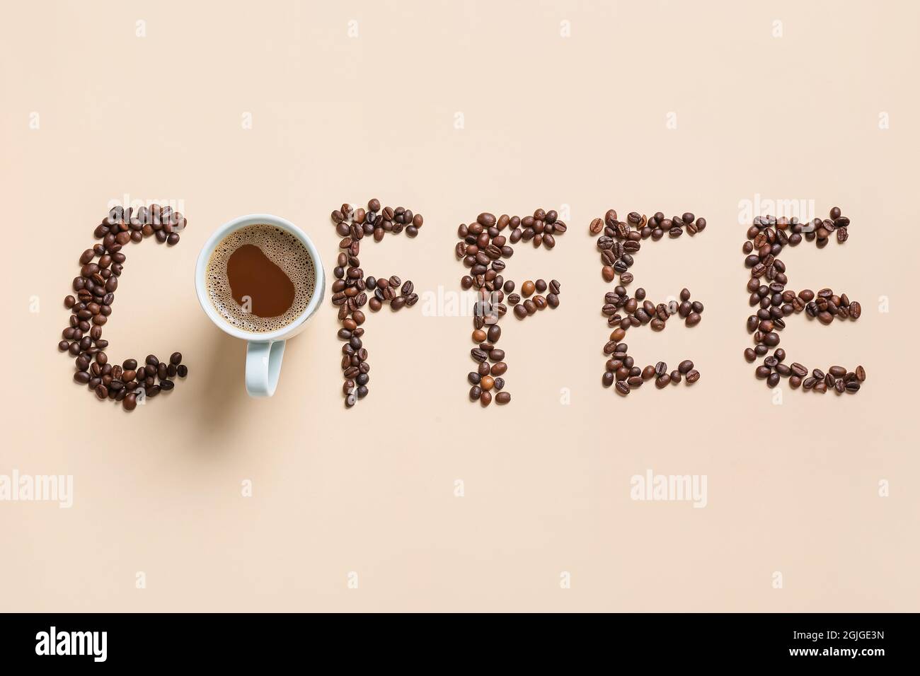 Cup of tasty coffee and word COFFEE made of beans on light background ...