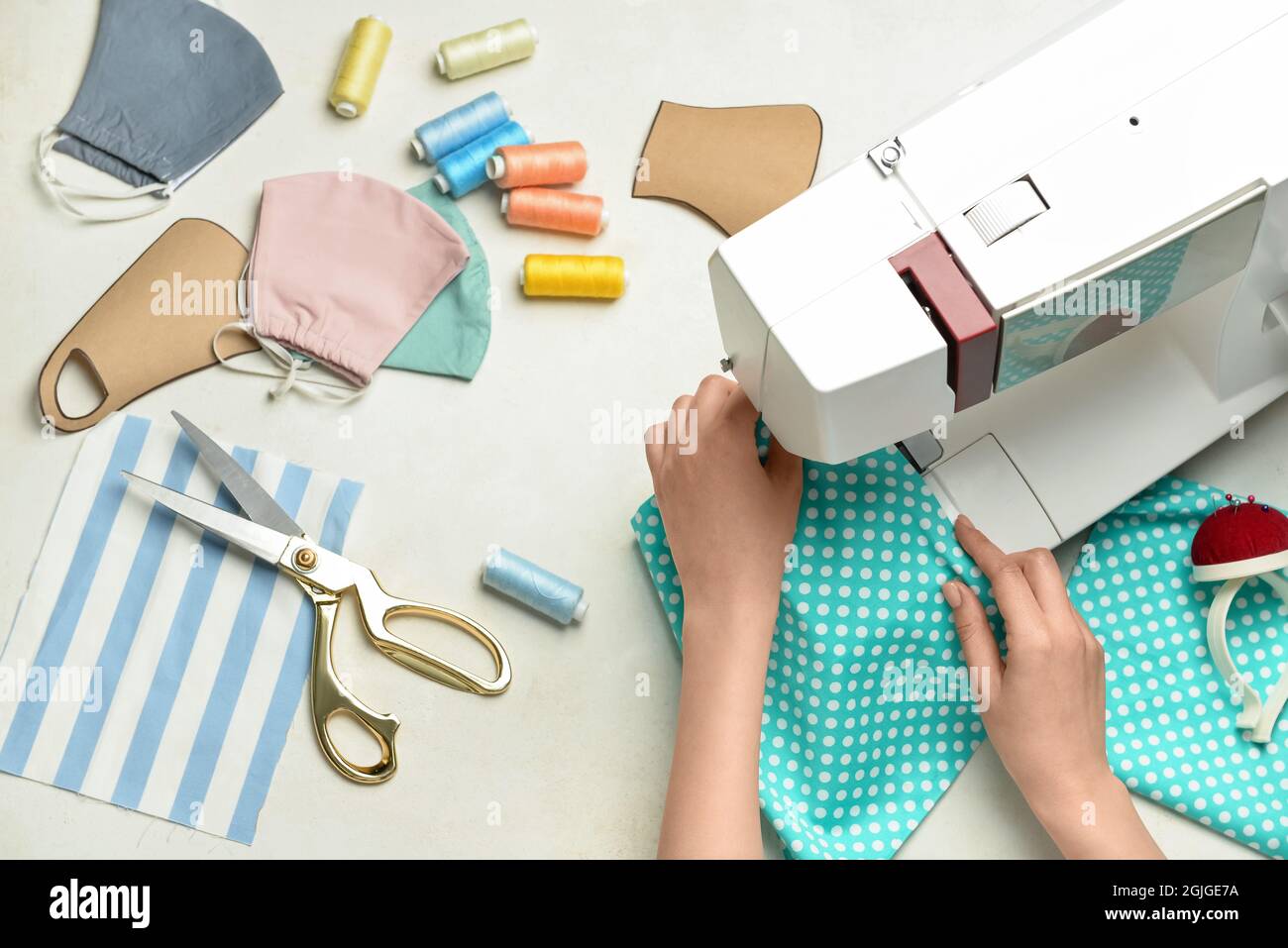 Woman sewing clothes on white background Stock Photo - Alamy