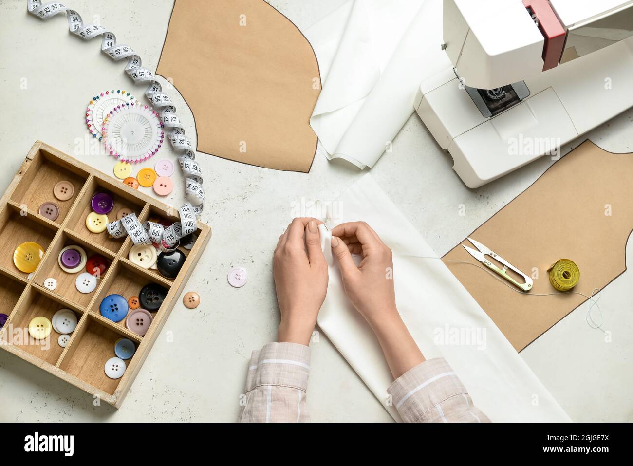 Woman sewing clothes on white background Stock Photo - Alamy
