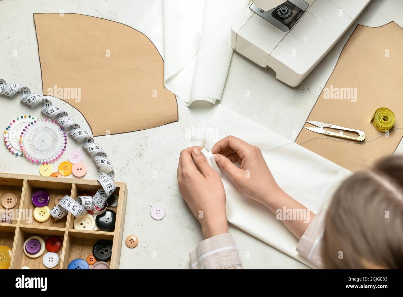 Woman sewing clothes on white background Stock Photo - Alamy