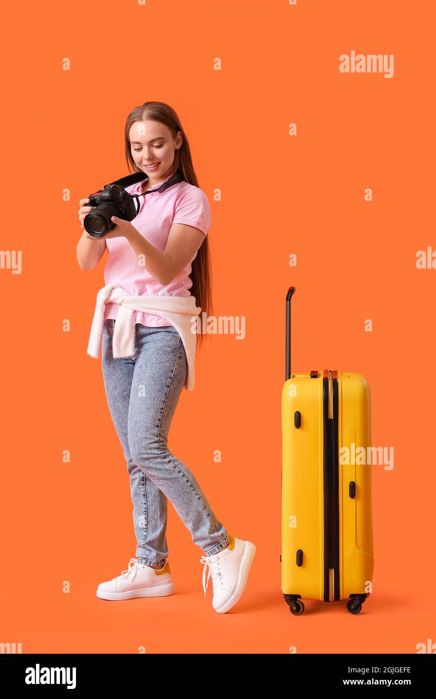 Female tourist with photo camera on color background Stock Photo - Alamy
