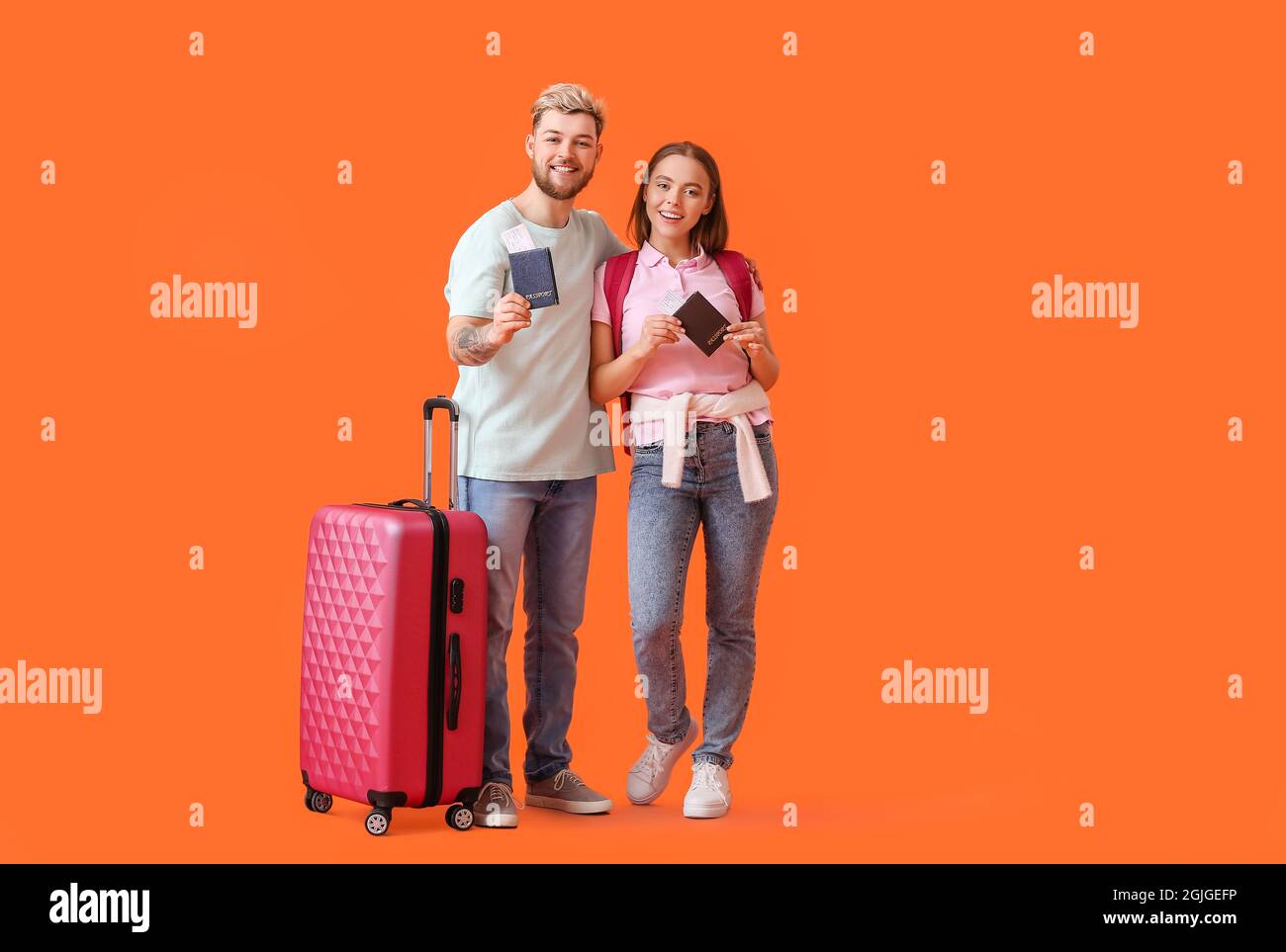 Couple of tourists on color background Stock Photo - Alamy