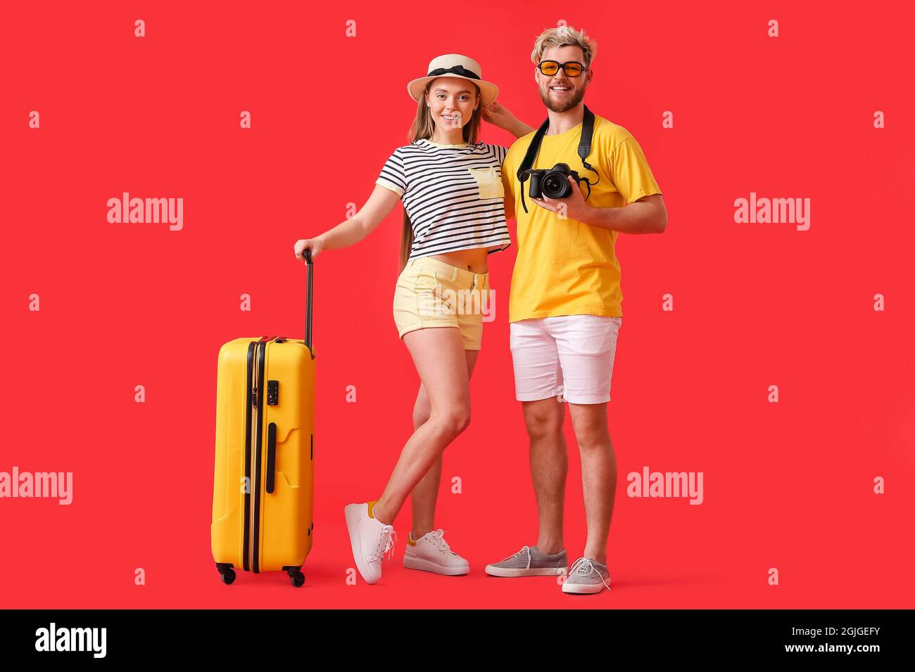 Couple of tourists on color background Stock Photo - Alamy