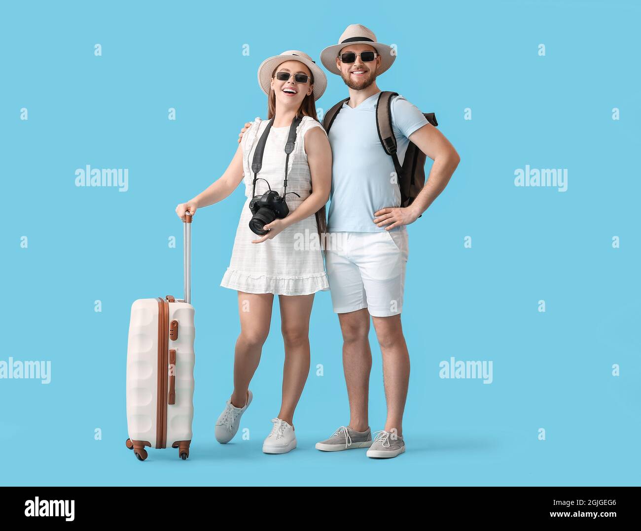 Couple of tourists on color background Stock Photo - Alamy