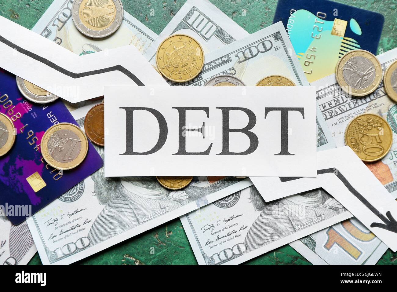 Paper with word DEBT and money on color background Stock Photo - Alamy