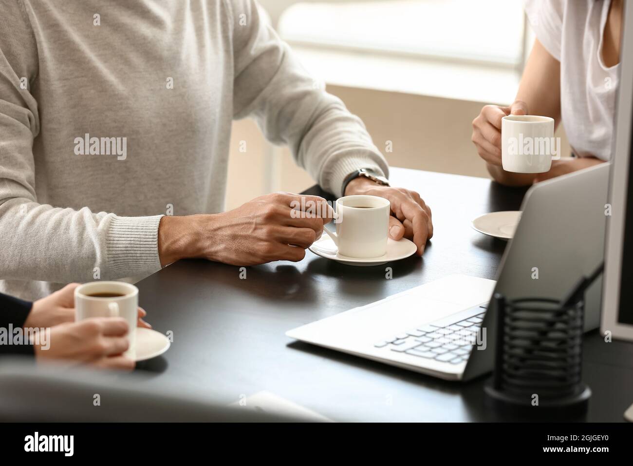 Business colleagues drinking coffee in office Stock Photo - Alamy