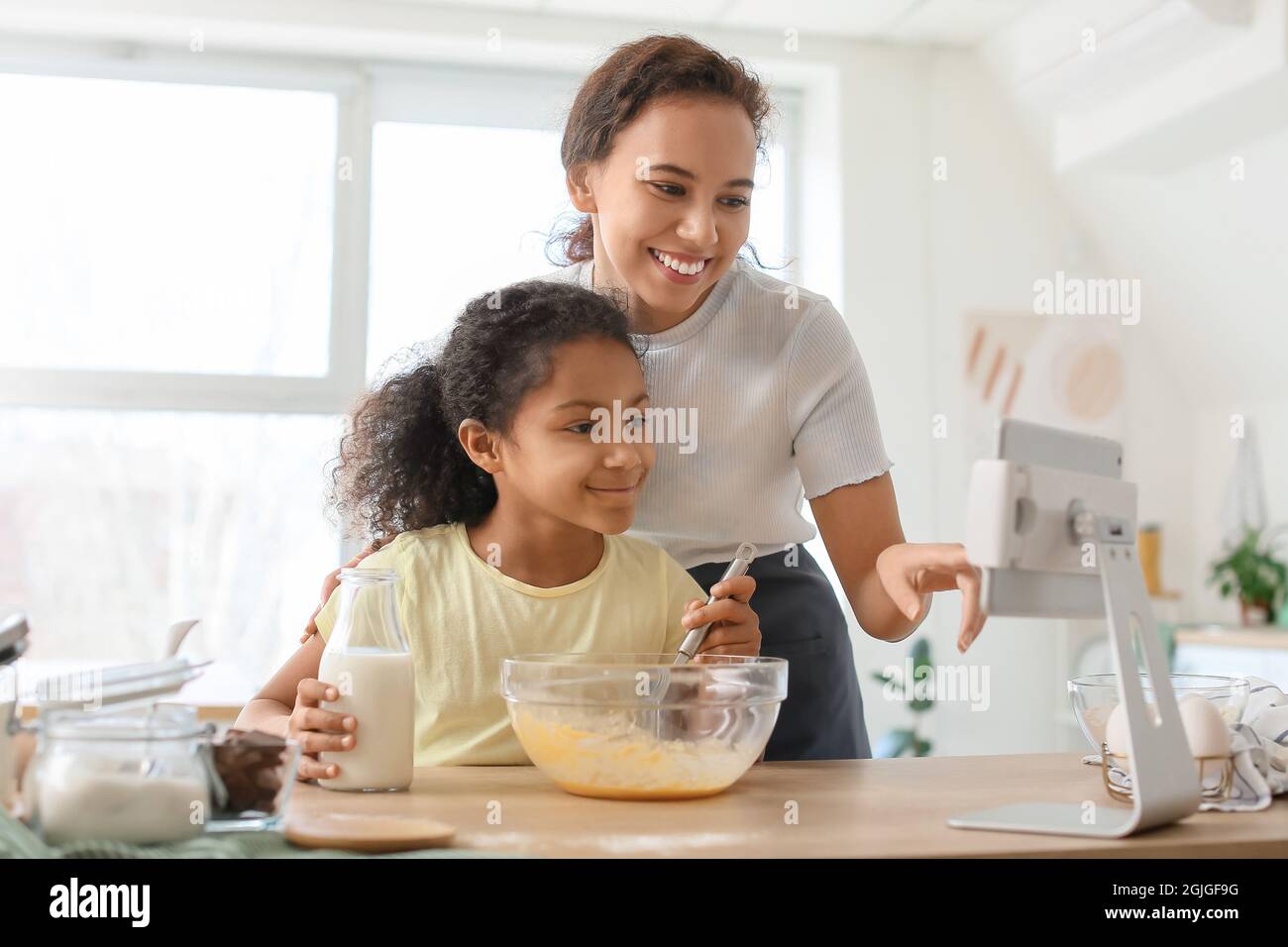 African-American little girl and her mother cooking in kitchen Stock ...