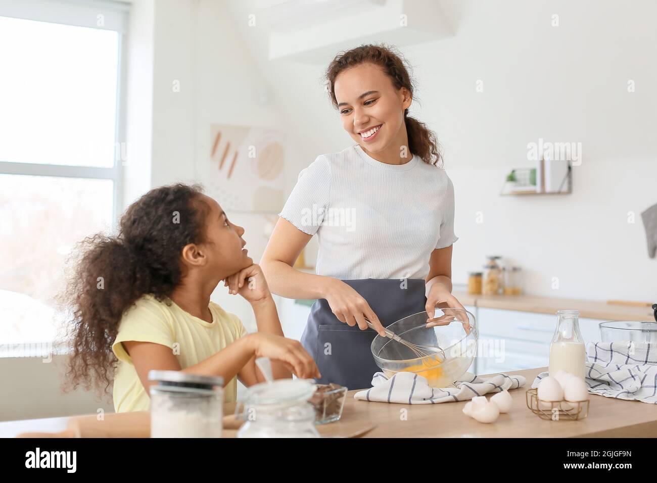 African-American little girl and her mother cooking in kitchen Stock ...