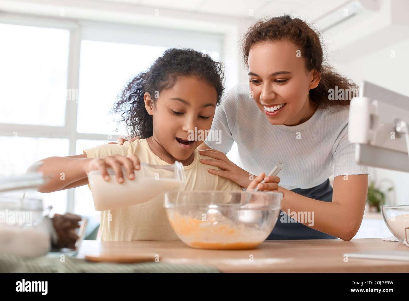 African-American little girl and her mother cooking in kitchen Stock ...