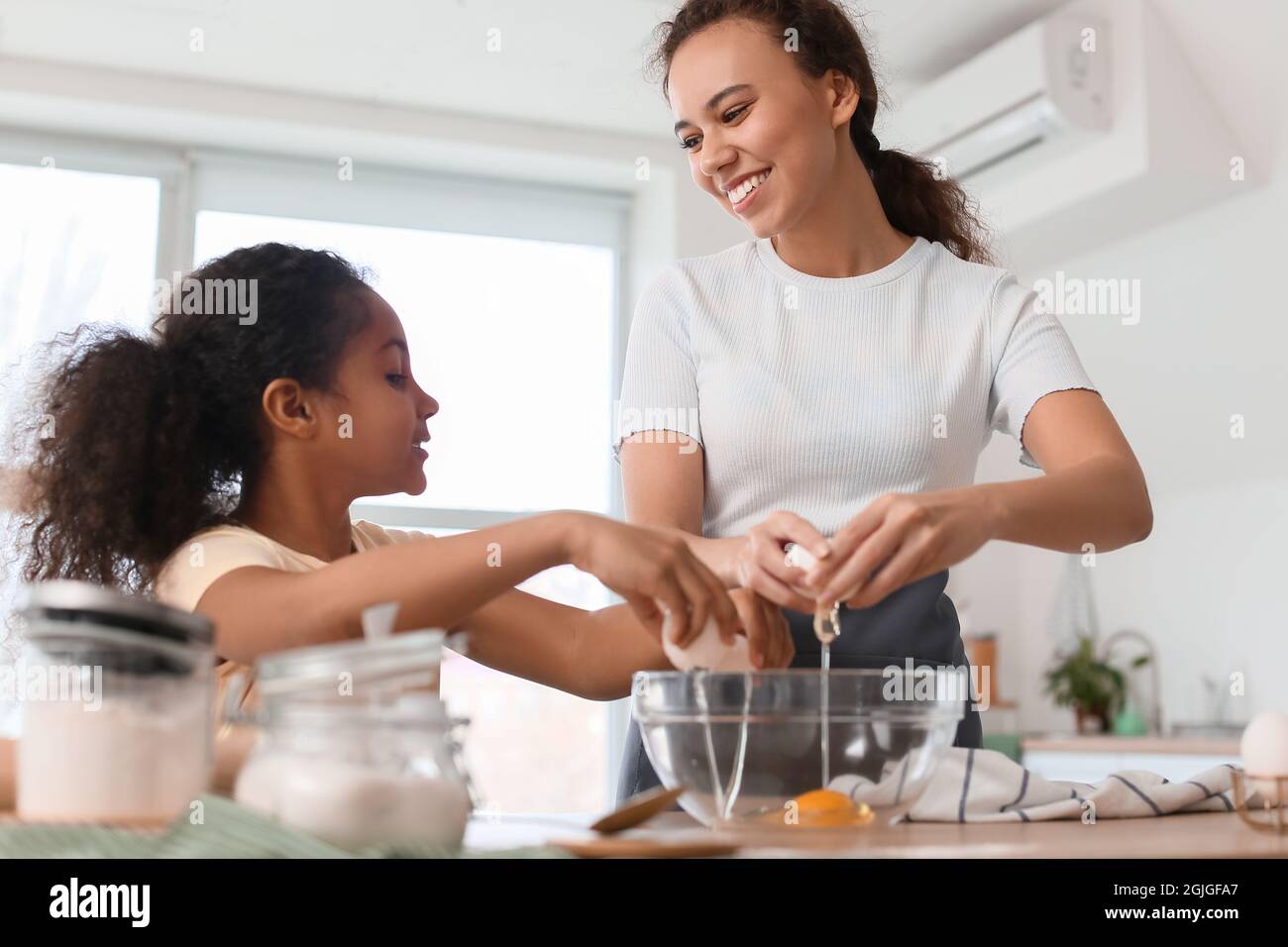 African-American little girl and her mother cooking in kitchen Stock ...