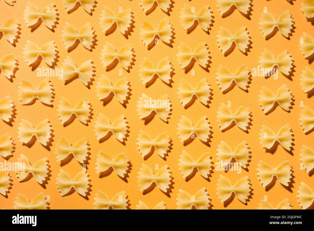 Uncooked farfalle pasta on color background Stock Photo - Alamy