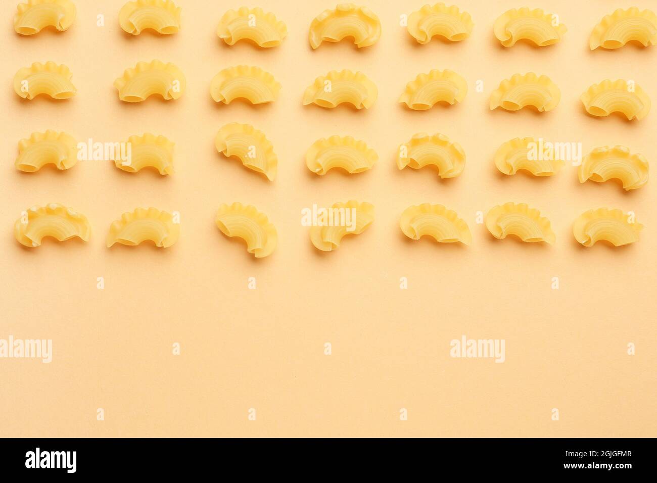 Uncooked creste pasta on color background Stock Photo - Alamy