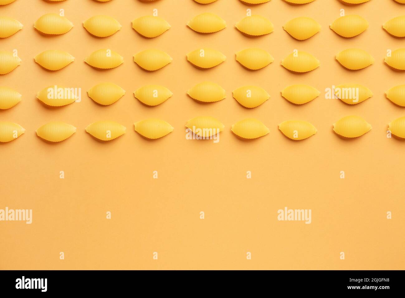 Uncooked conchiglioni pasta on color background Stock Photo - Alamy