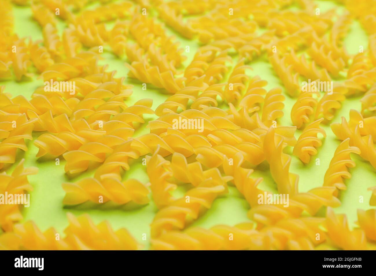 Uncooked fusilli pasta on color background Stock Photo - Alamy