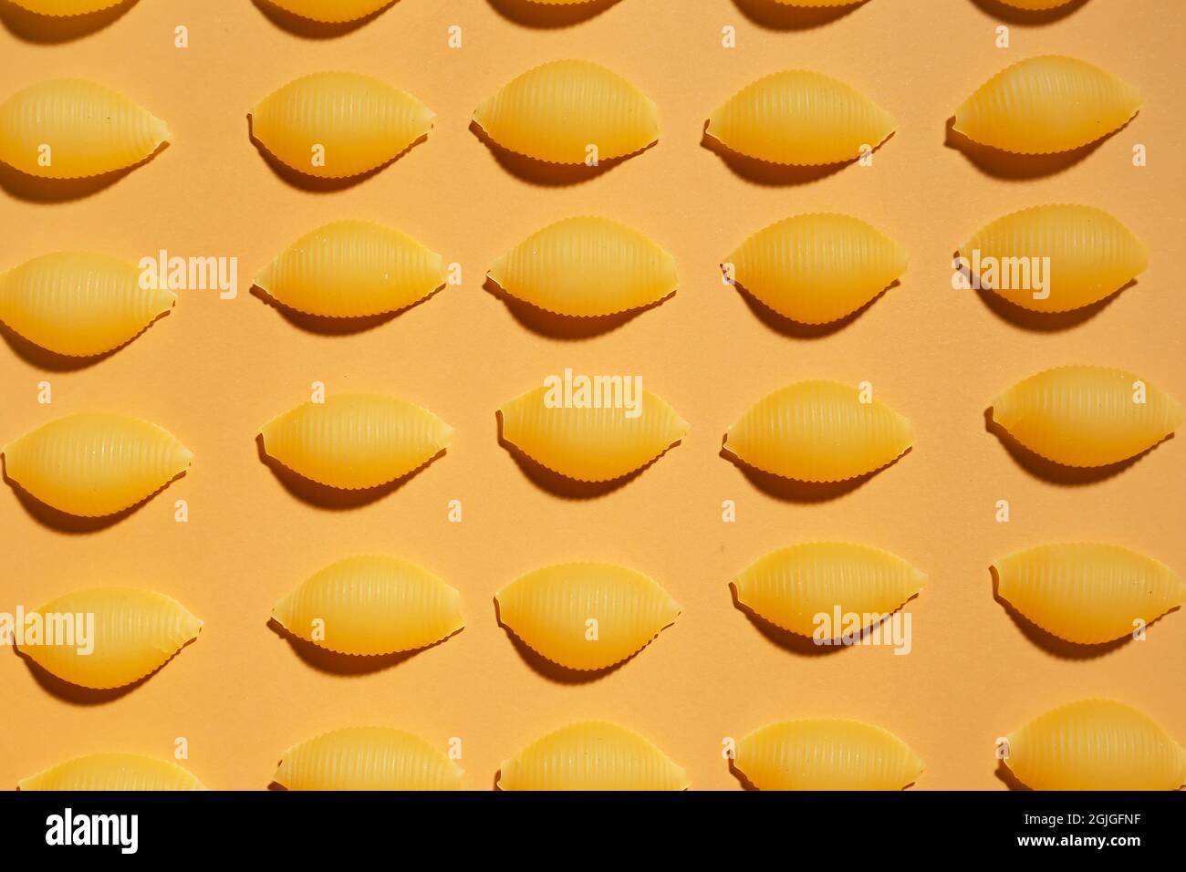 Uncooked conchiglioni pasta on color background Stock Photo - Alamy