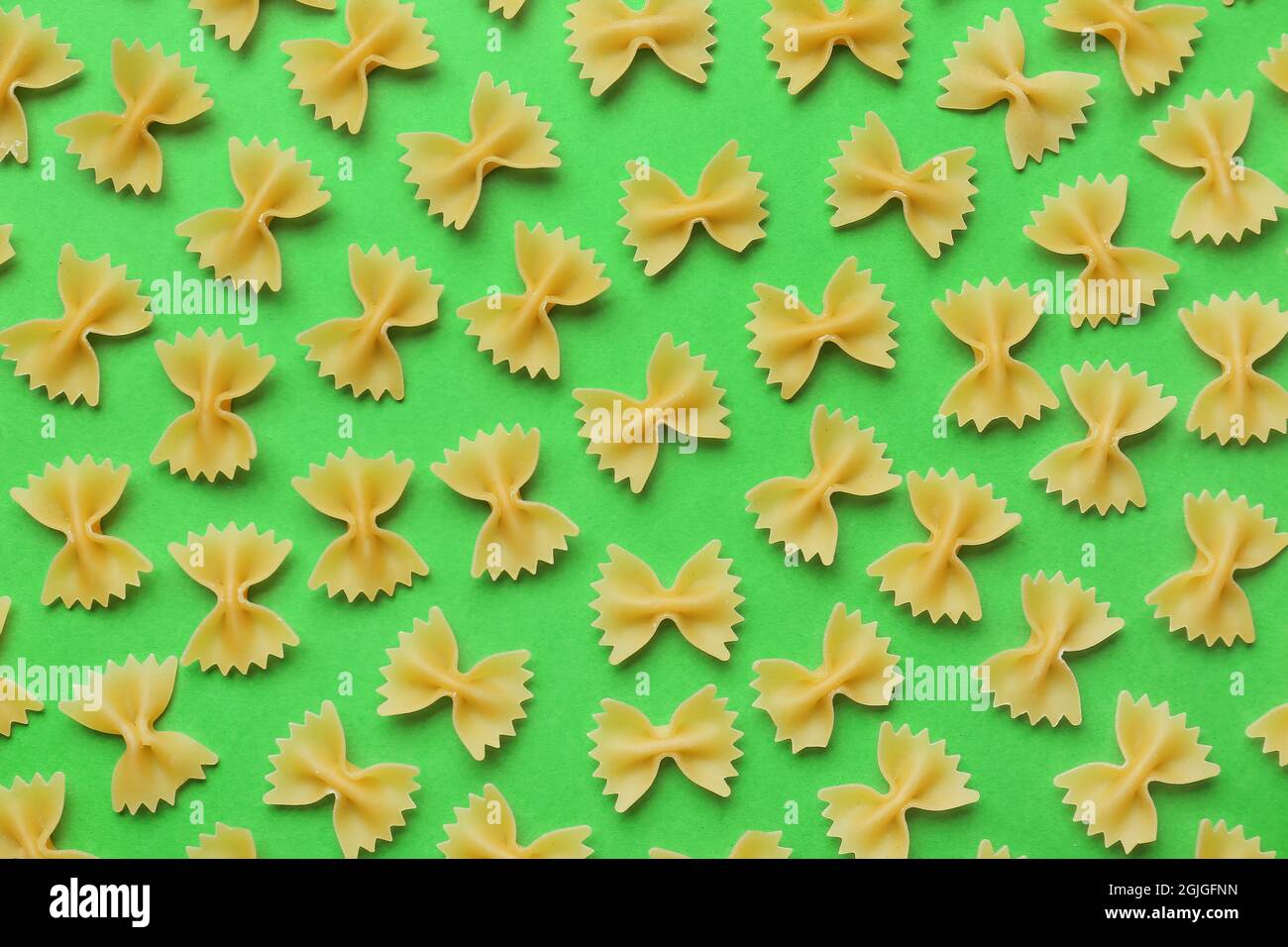 Uncooked farfalle pasta on color background Stock Photo - Alamy
