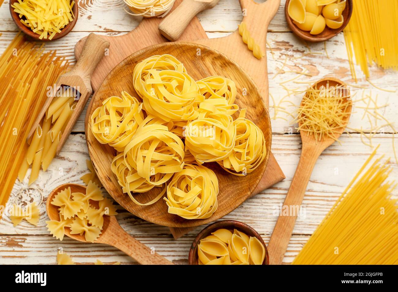 Different types of uncooked pasta on wooden background Stock Photo - Alamy