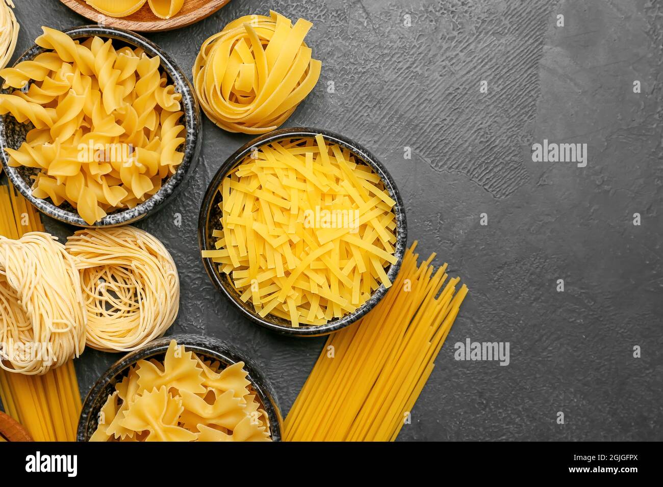 Different types of uncooked pasta on dark background Stock Photo - Alamy