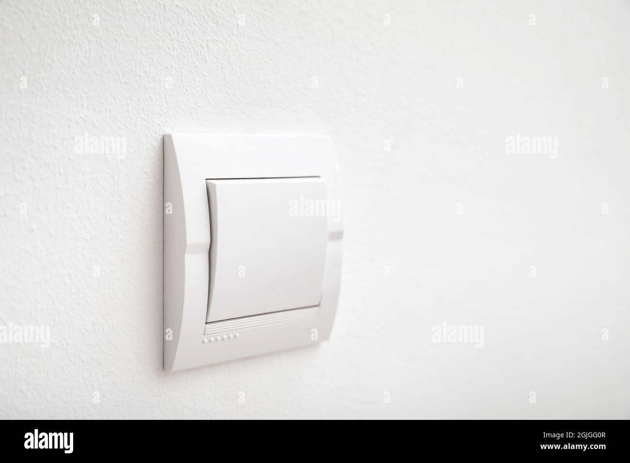 Modern light switch on white wall Stock Photo - Alamy