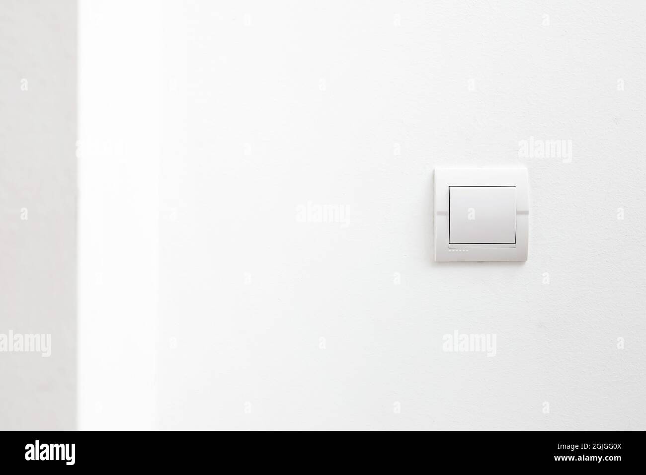 Modern light switch on white wall Stock Photo - Alamy