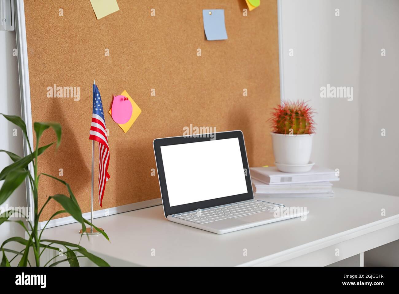 Modern workplace with laptop and USA flag in room Stock Photo - Alamy