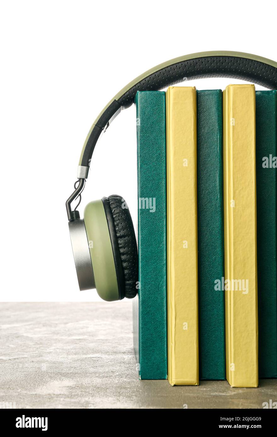 Modern headphones with books on table against white background Stock ...