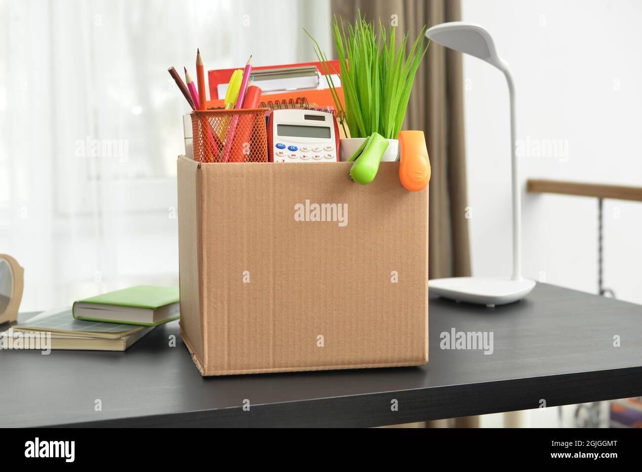 Box with personal stuff on table in office Stock Photo - Alamy
