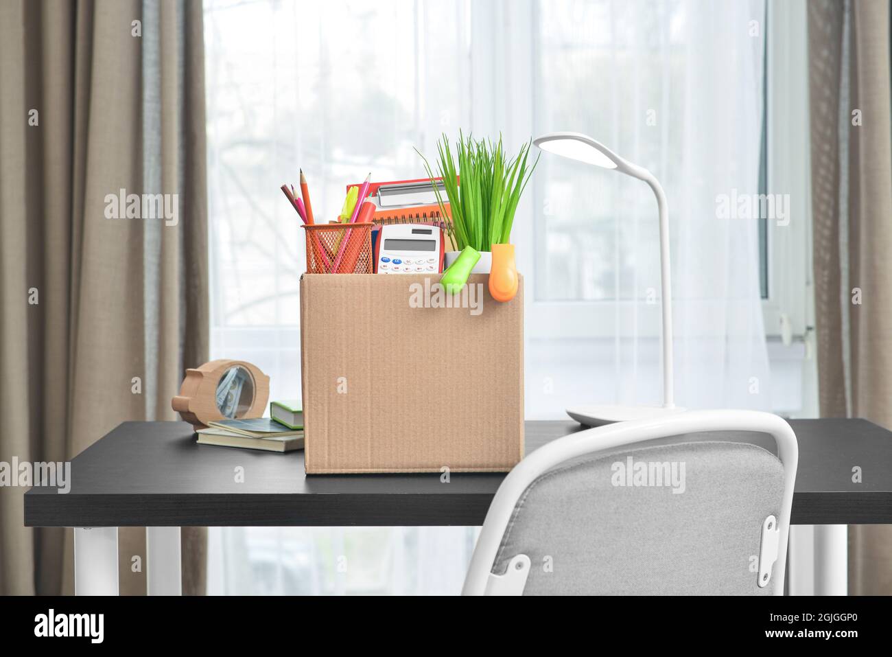 Box with personal stuff on table in office Stock Photo - Alamy