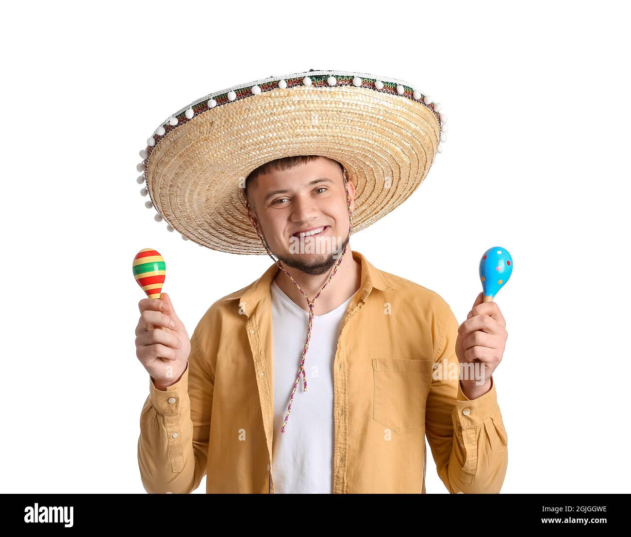 Young Mexican man in sombrero hat and with maracas on white background ...