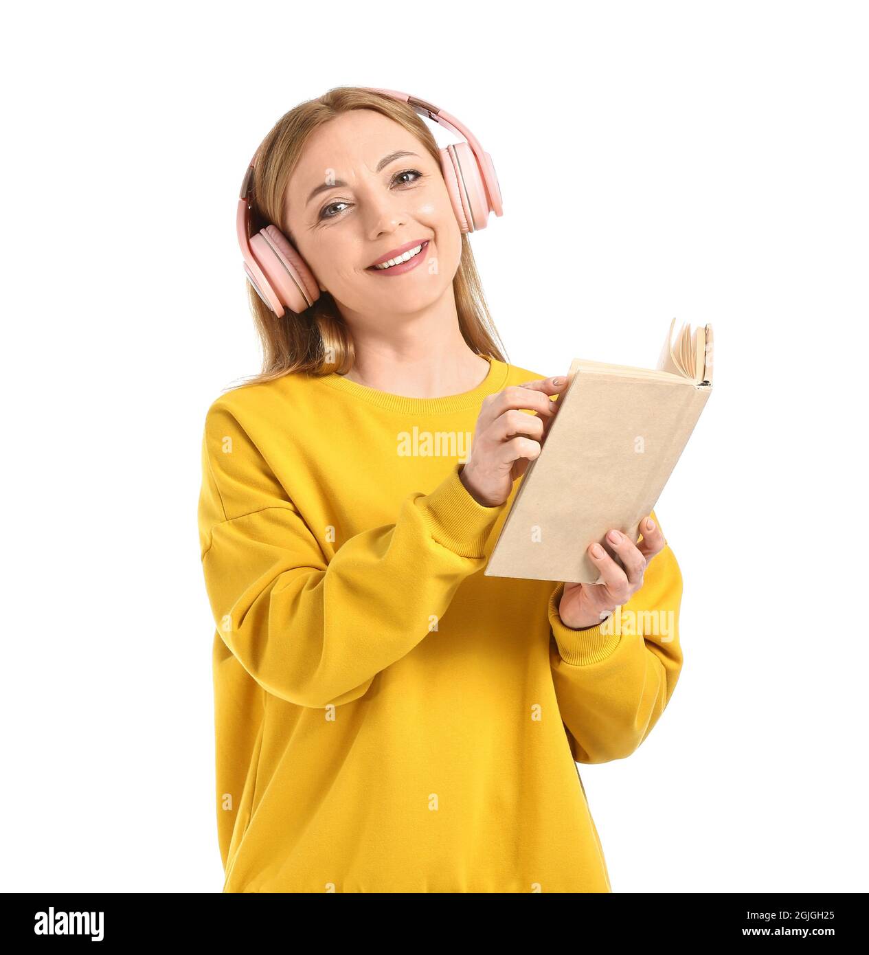 Mature woman with headphones reading book on white background Stock ...