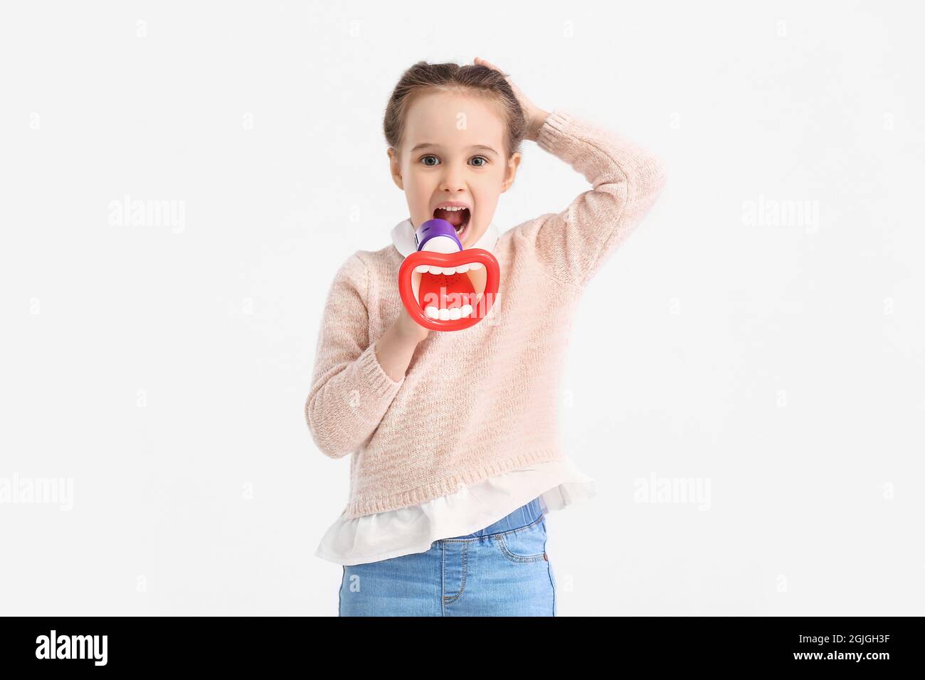 Little girl shouting into megaphone on white background Stock Photo - Alamy