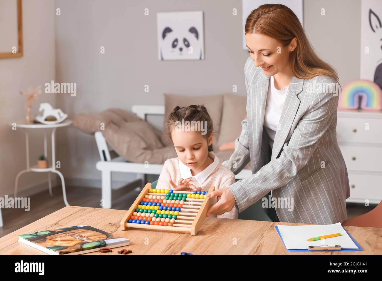 Female psychologist working with girl suffering from autistic disorder ...