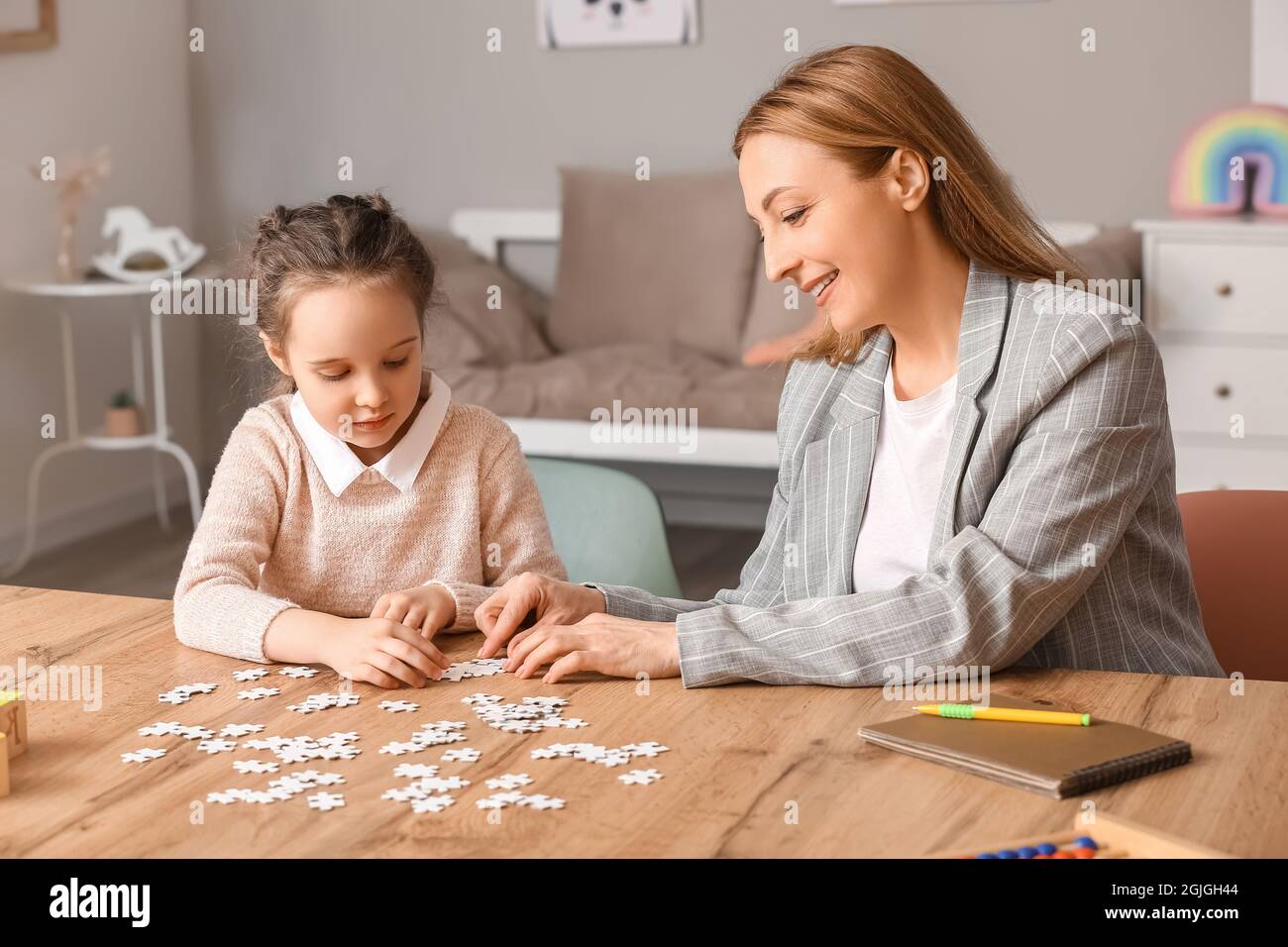 Female psychologist working with girl suffering from autistic disorder ...