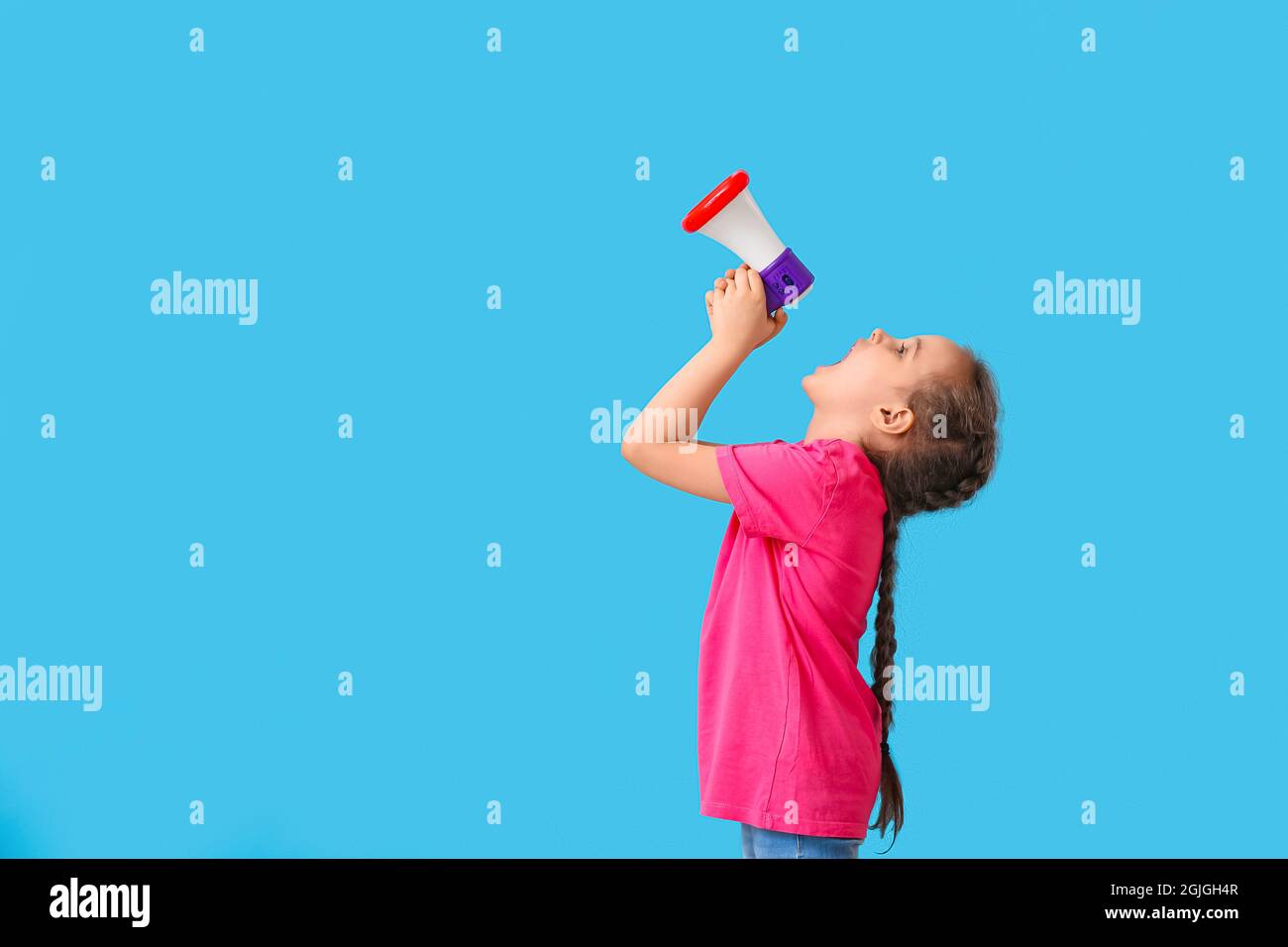 Little girl shouting into megaphone on color background Stock Photo - Alamy