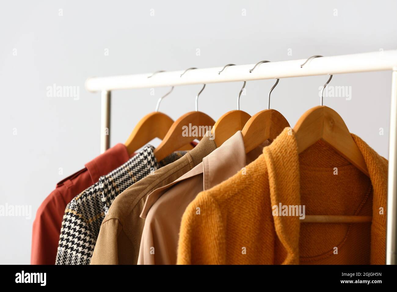 Rack with clothes on light background, closeup Stock Photo - Alamy