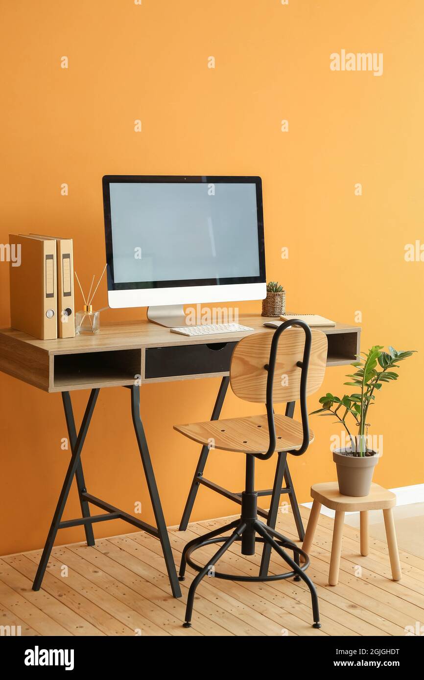 Modern workplace with computer near color wall Stock Photo - Alamy