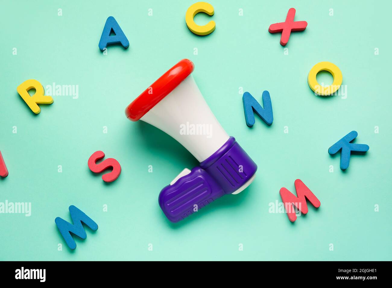 Toy megaphone with letters on color background Stock Photo - Alamy