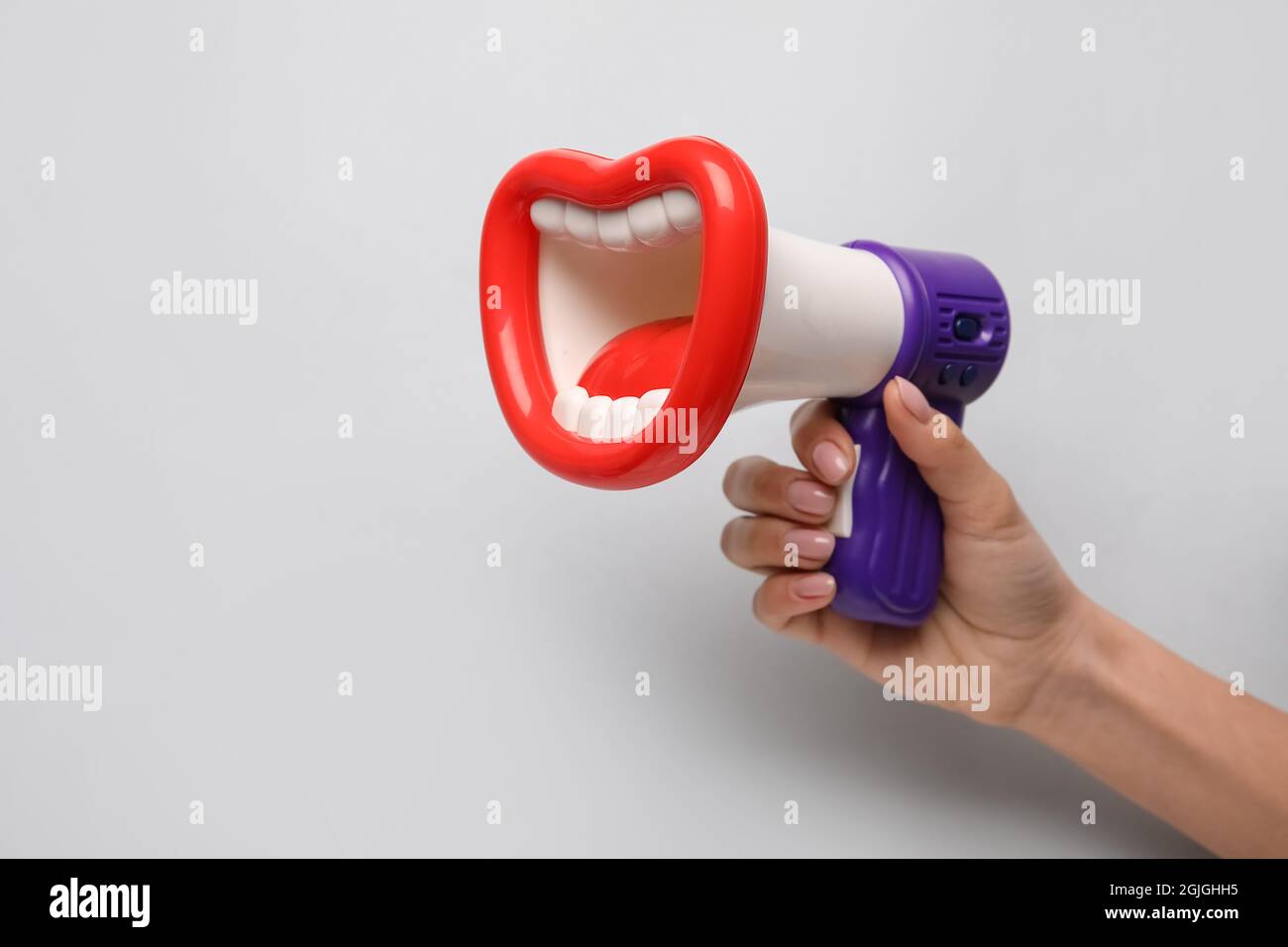 Woman with toy megaphone on light background Stock Photo - Alamy